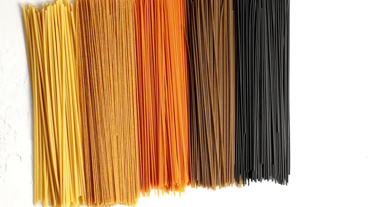 Premium stock video - Uncooked multicolored spaghetti