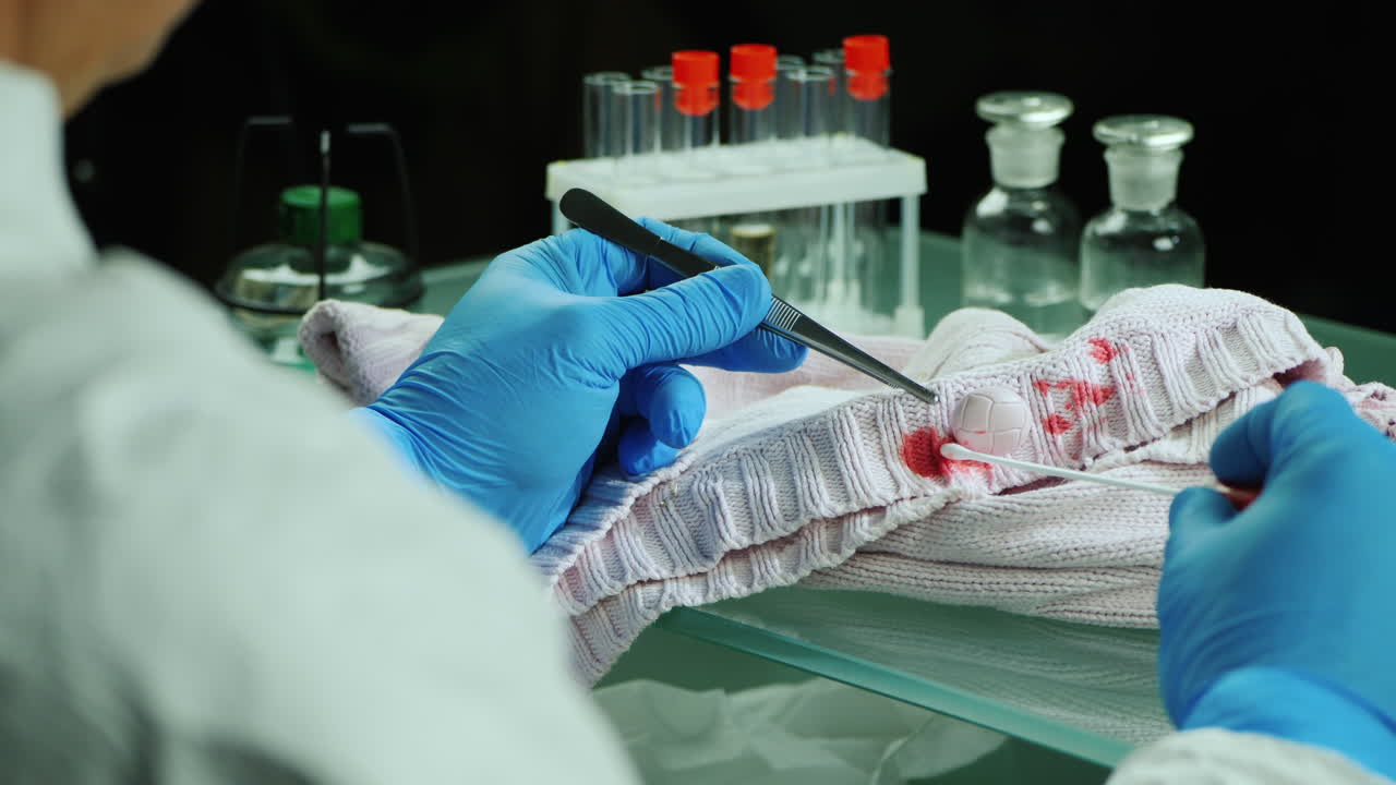 Premium stock video - Crime lab worker examines evidence on clothes 4