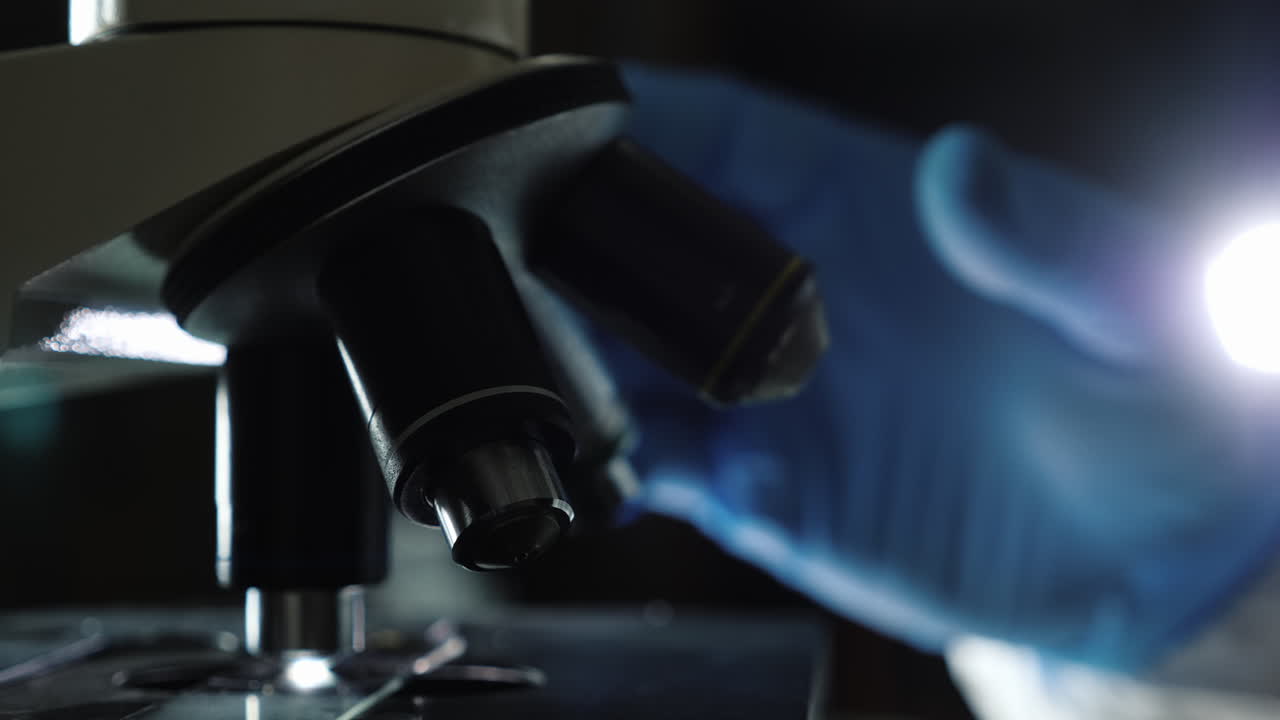 Premium stock video - Changing lenses on a microscope