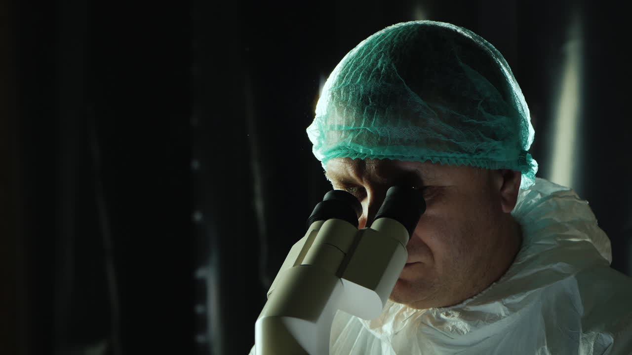 Premium stock video - Researcher in viral lab works with microscope and ...