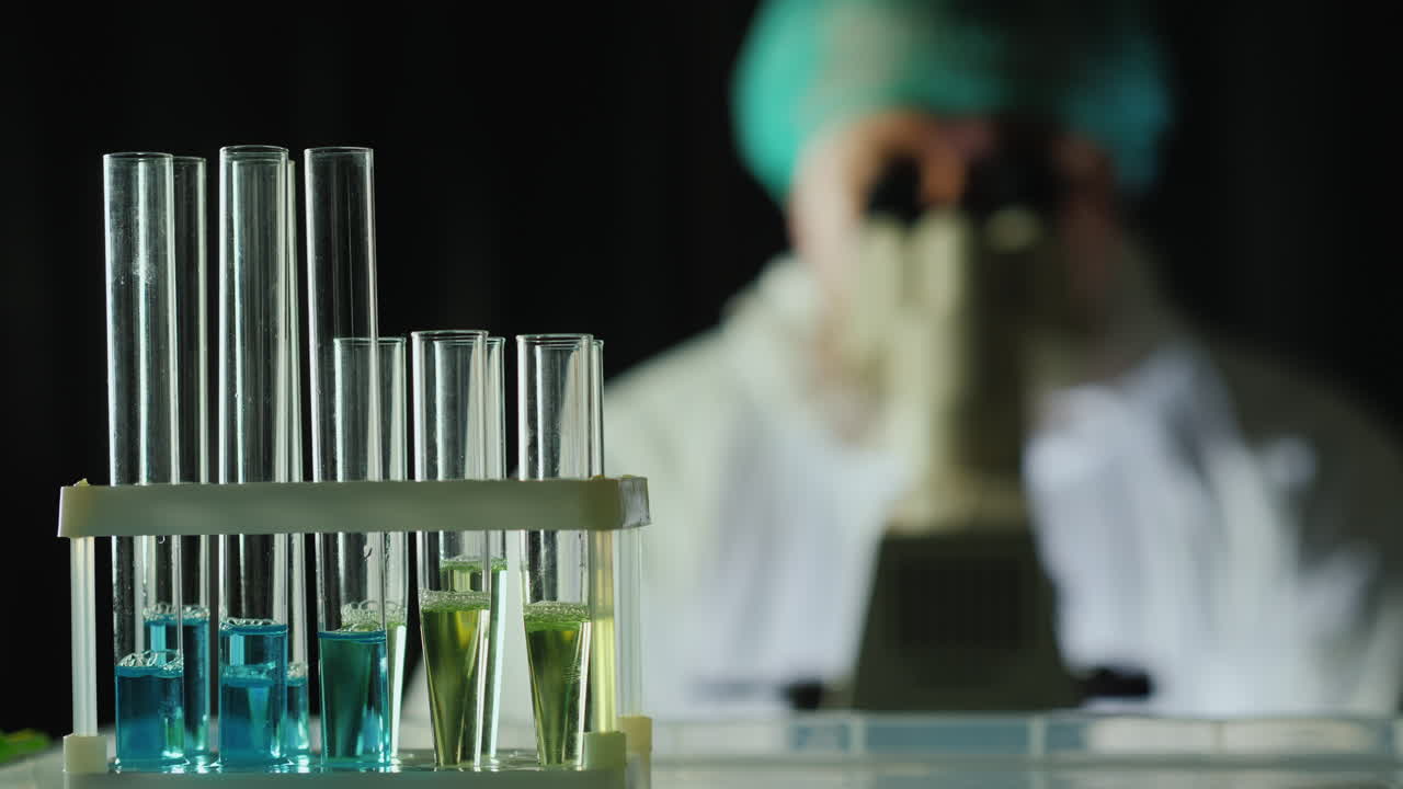 Premium stock video - Test tubes in the lab as a man works with a ...