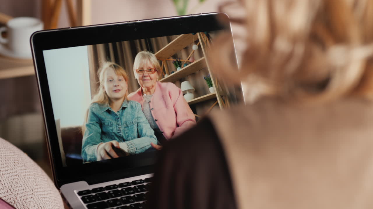 Premium stock video - A woman talks to an elderly lady and child via ...