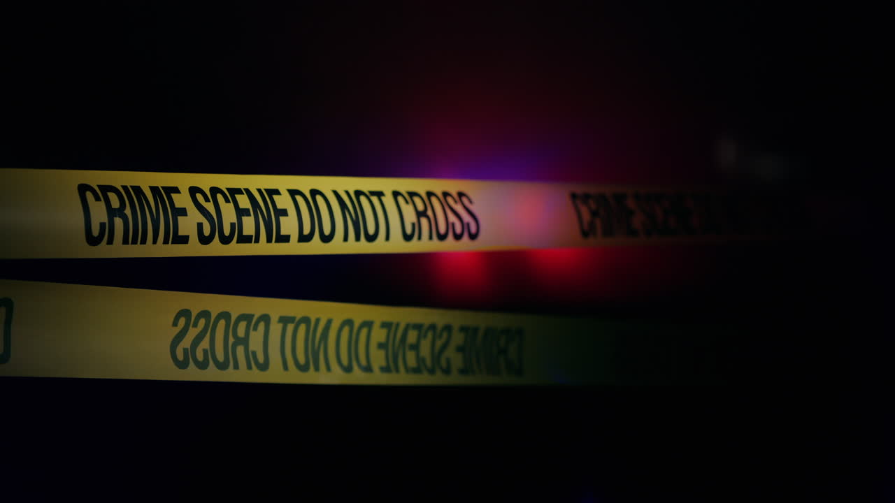 Premium stock video - Yellow ribbons encloses crime scene lit by police ...