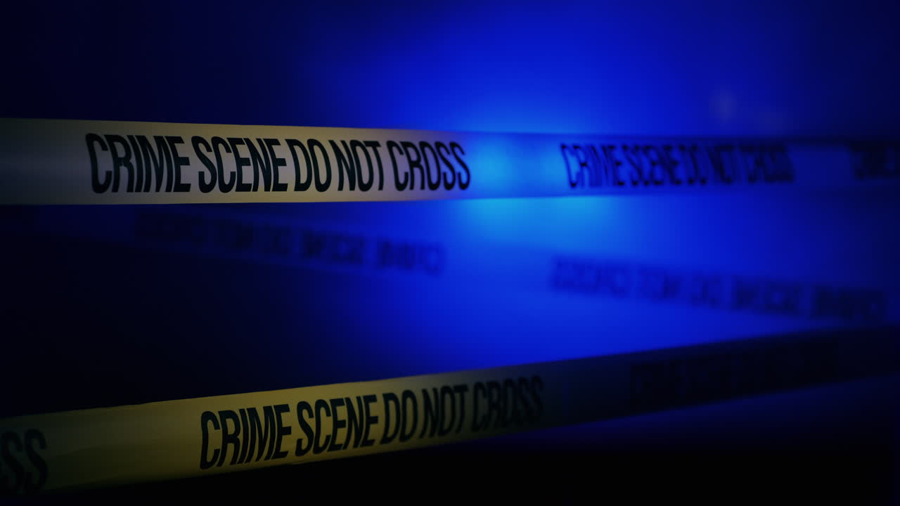 Premium stock video - Yellow ribbons encloses crime scene lit by police ...