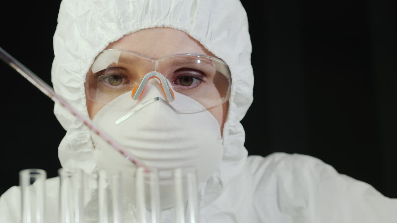 Premium stock video - A man in a biological protection suit works in a ...