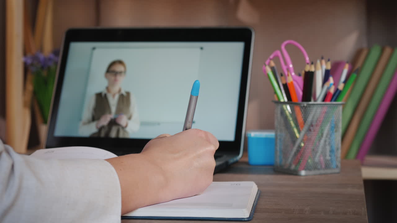 Premium stock video - Female student studies at home near laptop ...