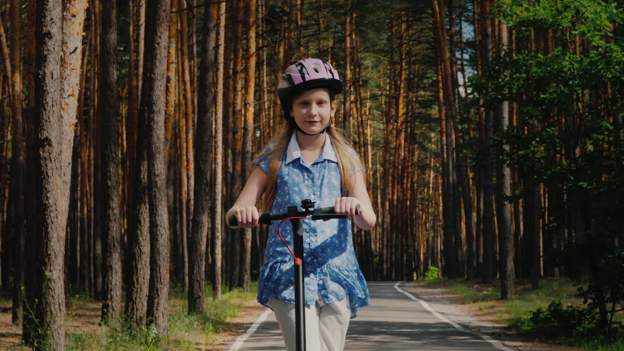 Premium stock video - Joyful child rides an electric scooter on the ...