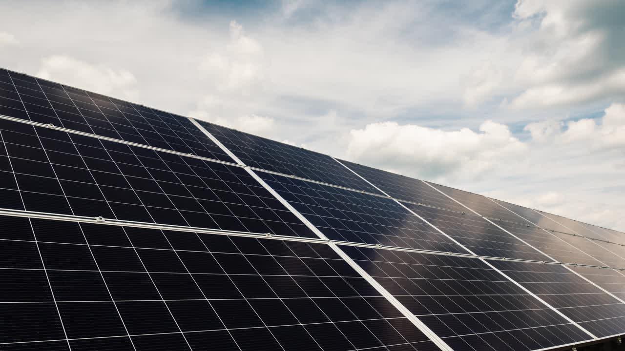 Premium stock video - Clouds float quickly over solar power plant panels