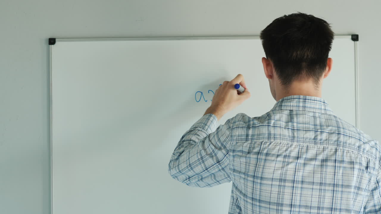 Premium stock video - Student writes on equation board