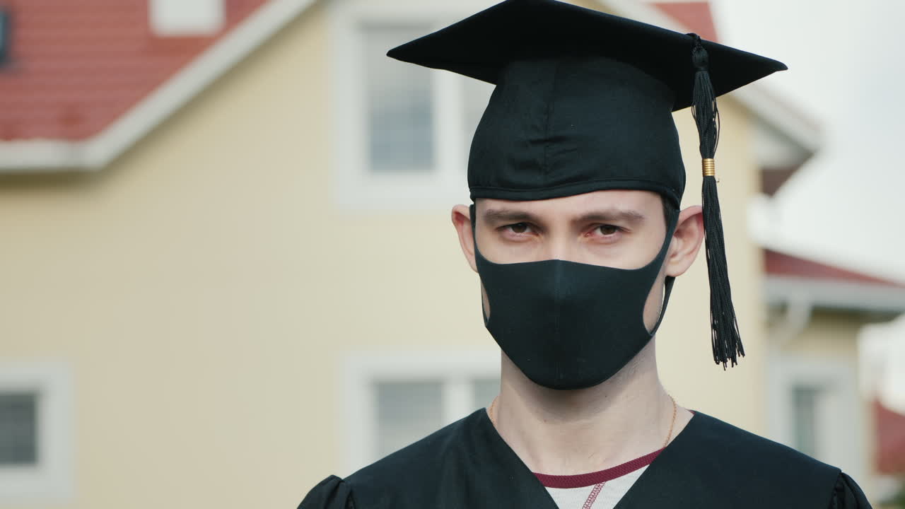 Premium stock video - Portrait of a graduate in a protective mask ...