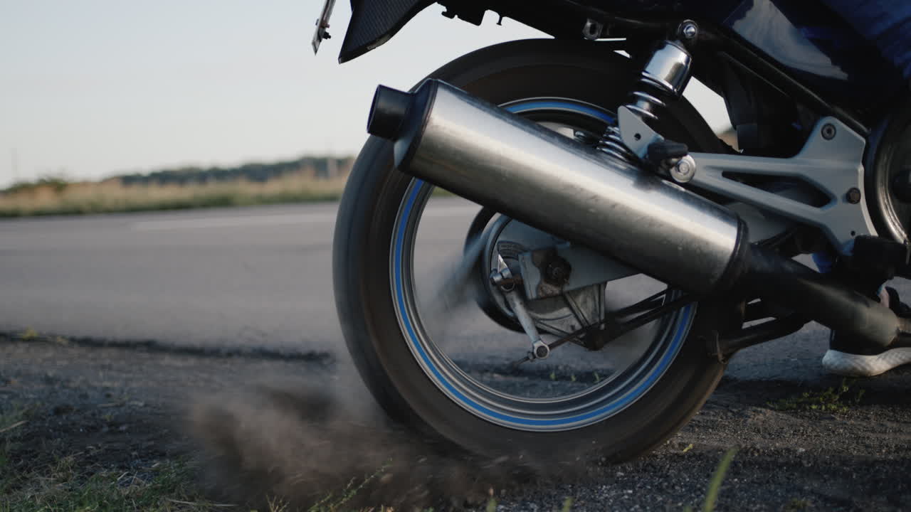 Premium stock video - The wheel of the motorcycle skids through gravel