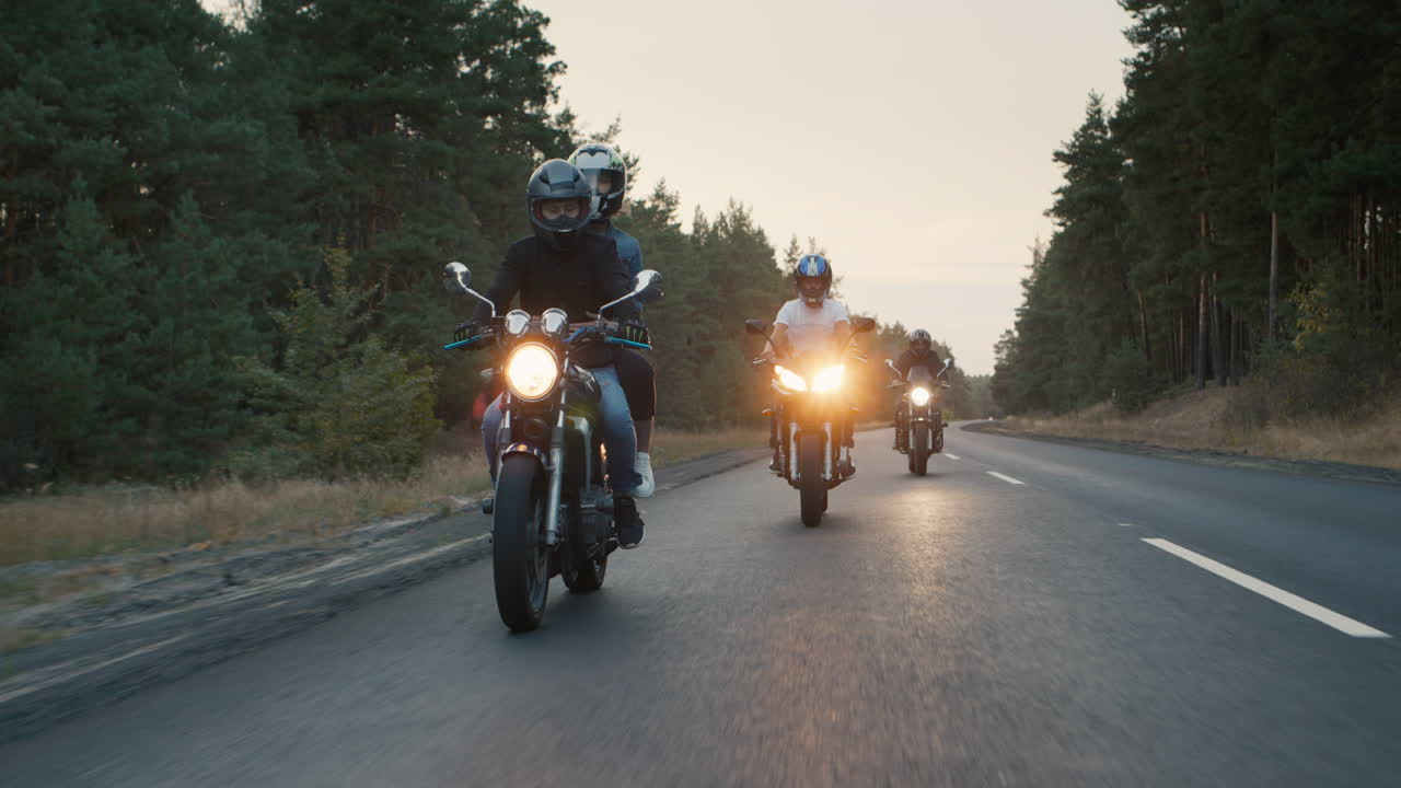 Premium stock video - Bikers ride on the road among the pine forest 1