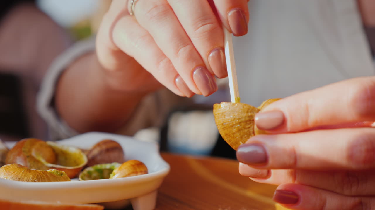 Premium stock video - Tourists taste cooked snails