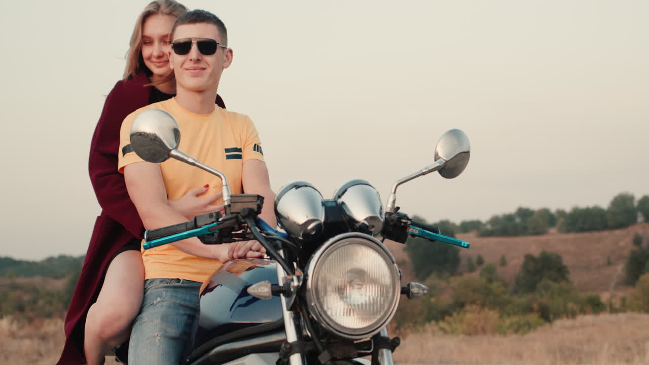 Premium stock video - Romantic couple sit on a motorcycle and admire ...