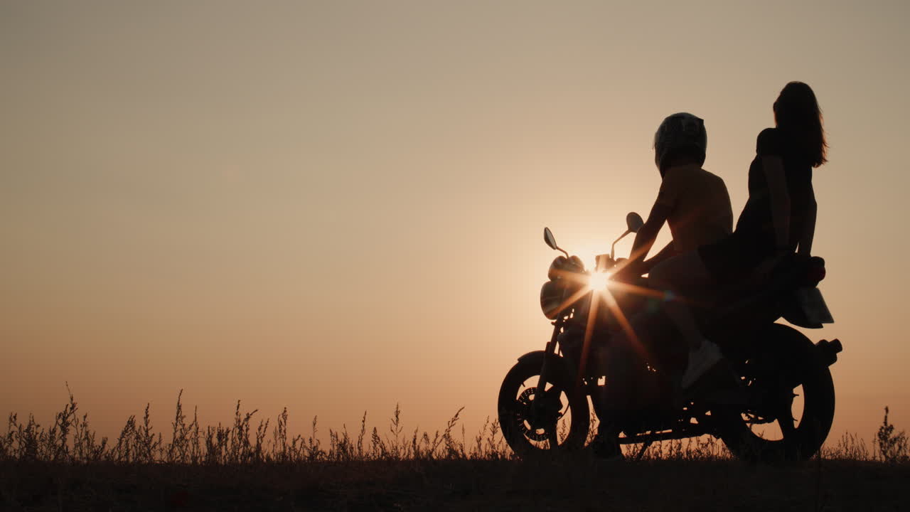 Premium stock video - Silhouettes of a romantic couple sit on a ...