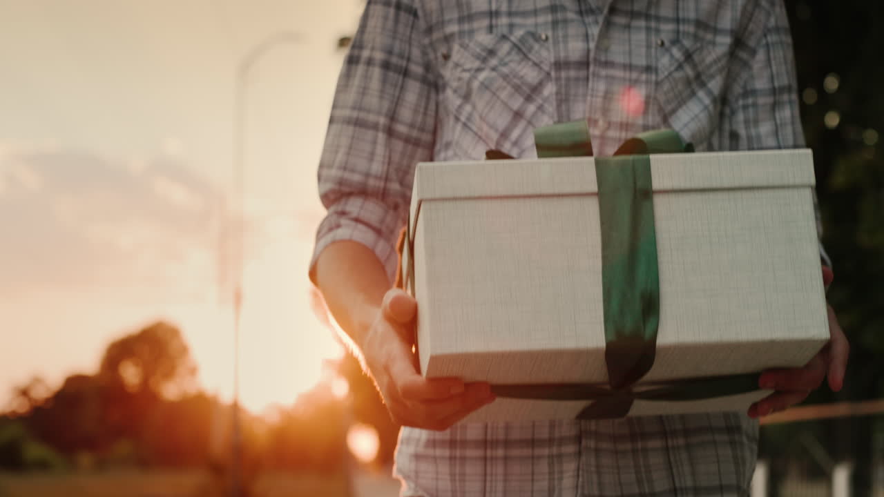 Premium stock video - A man carries a beautifully packed box with a ...