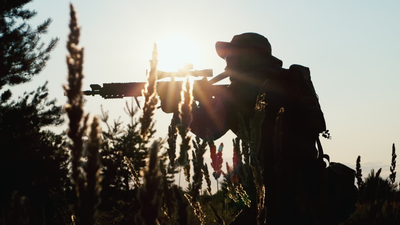 Premium stock video - Silhouette of a sniper aiming with a rifle