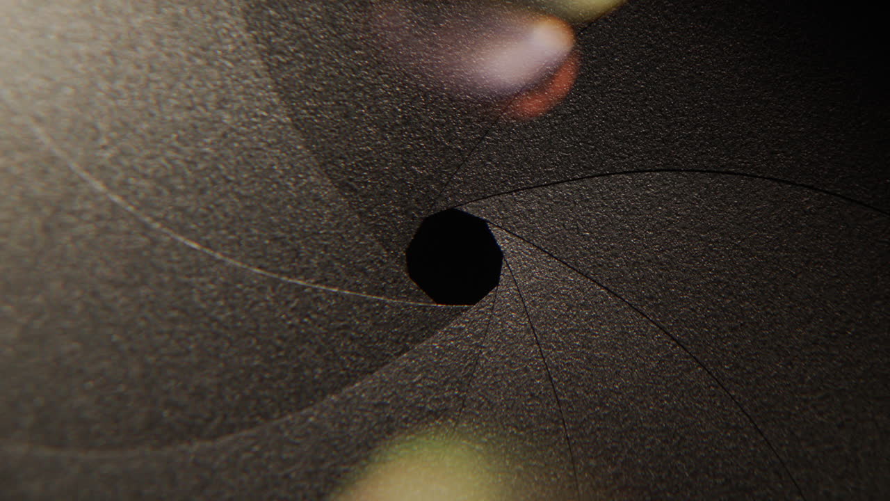 Premium stock video - Close-up of the lens's aperture illuminated by a ...