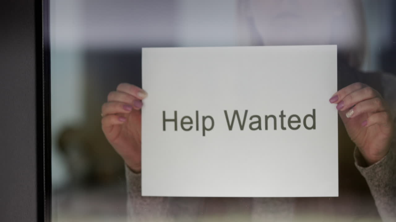 Premium stock video - Employee hangs on the door ad help wanted