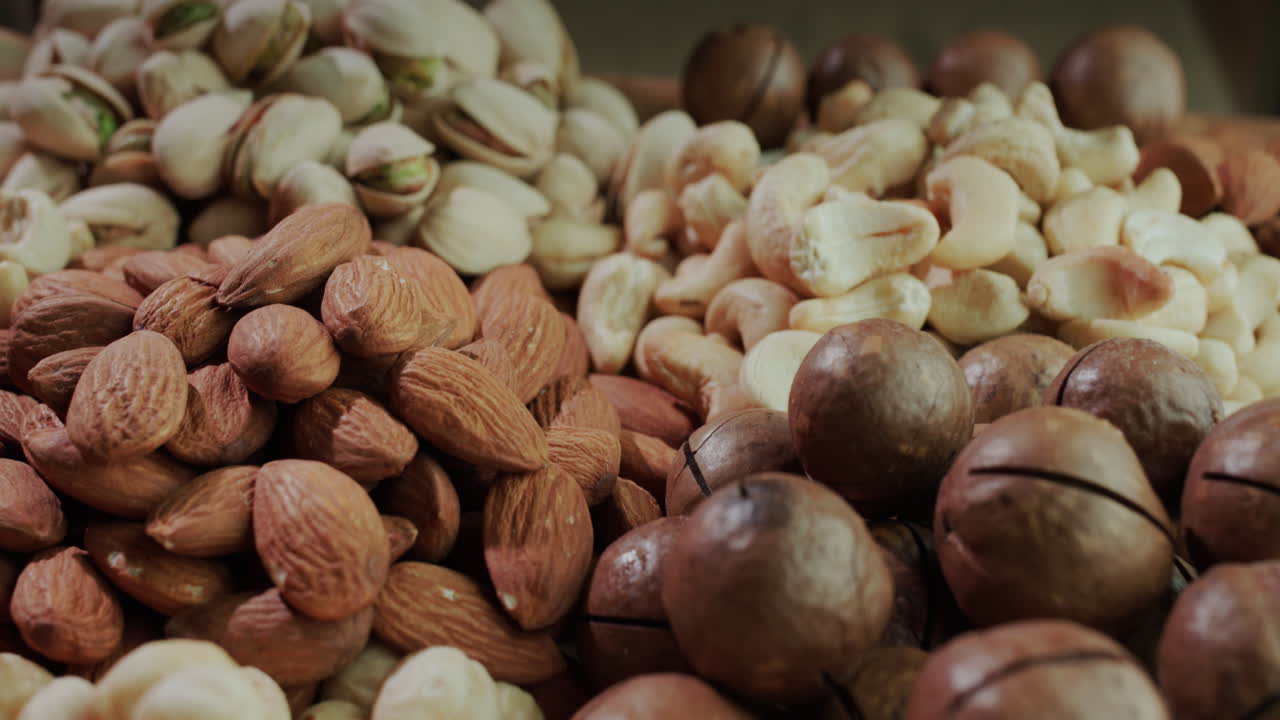 Premium stock video - Handfuls of ready-to-eat nuts of different varieties