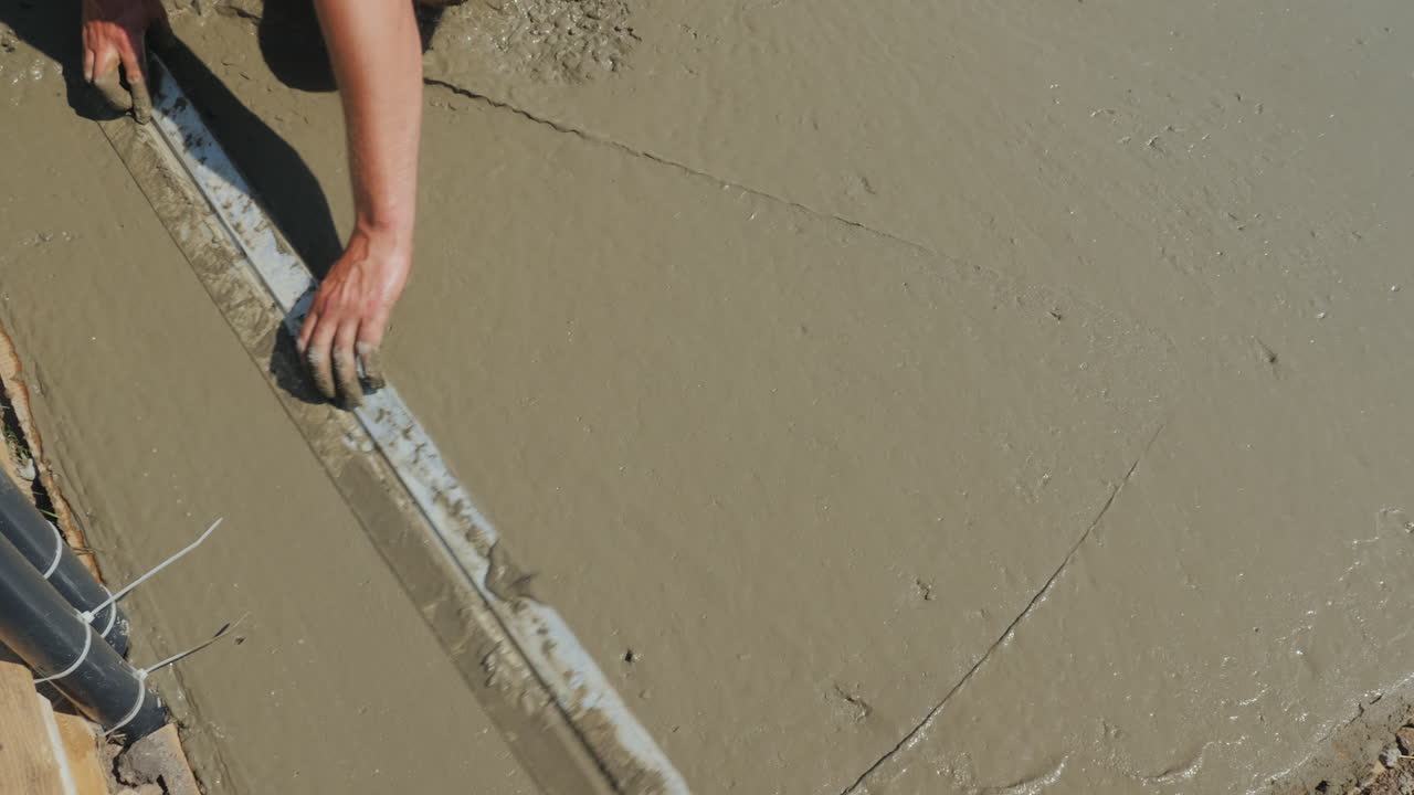 Premium stock video - The builder levels the liquid concrete