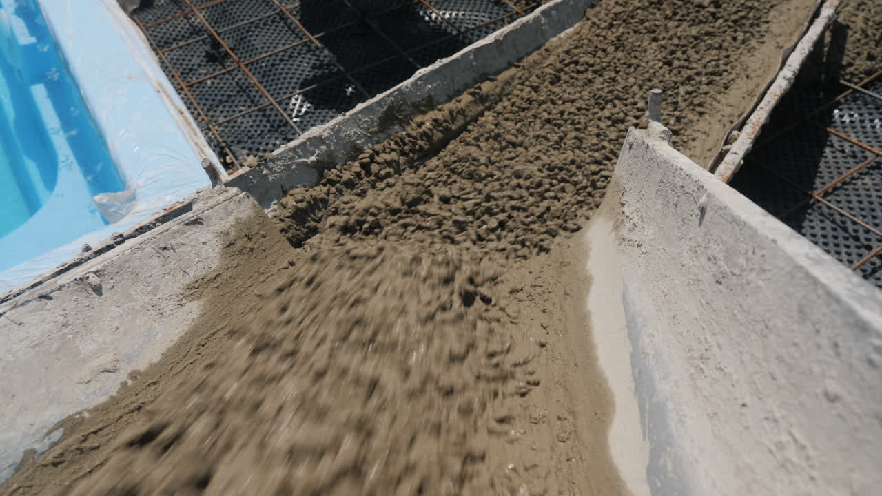 Premium stock video - Concrete flows down the gutters where workers ...