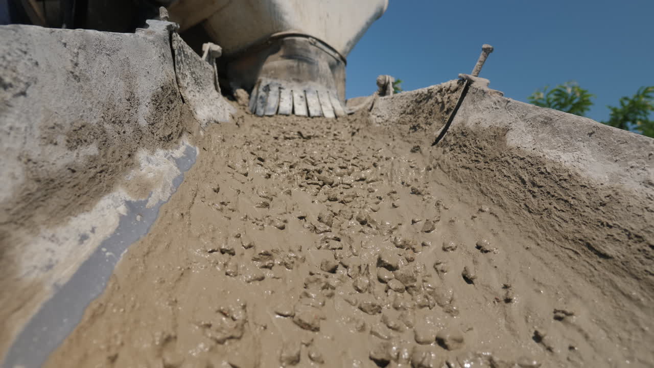 Premium stock video - Concrete flows from the concrete mixer through a ...