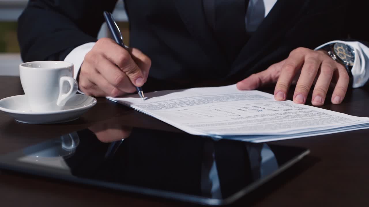 Premium stock video - Businessman signs an important document 1