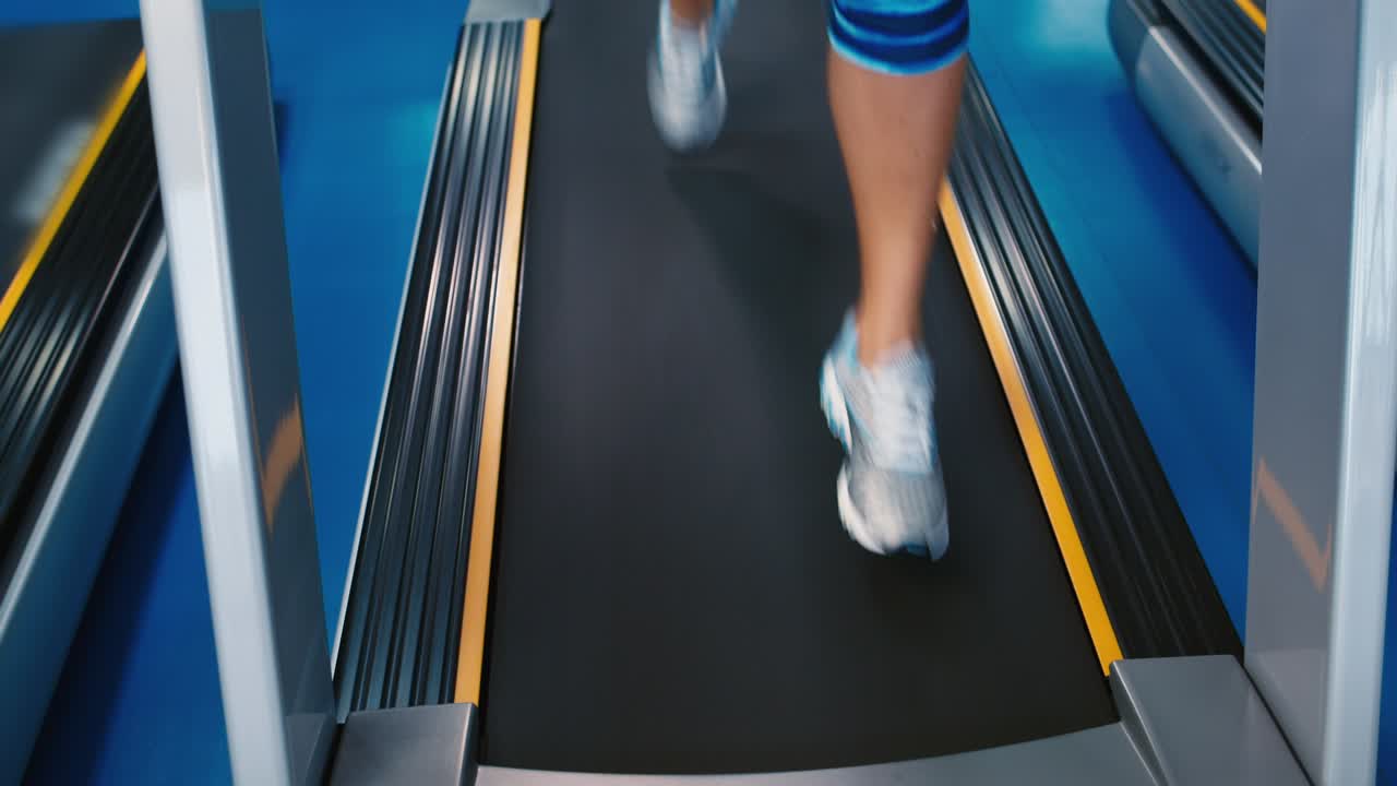 Premium stock video - Runner's legs on the treadmill close-up