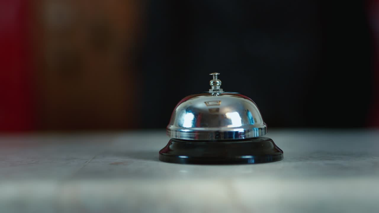 Premium stock video - Hand strikes the bell at the reception desk