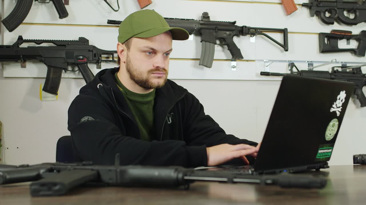 Premium stock video - Man behind a counter in an arms store 4