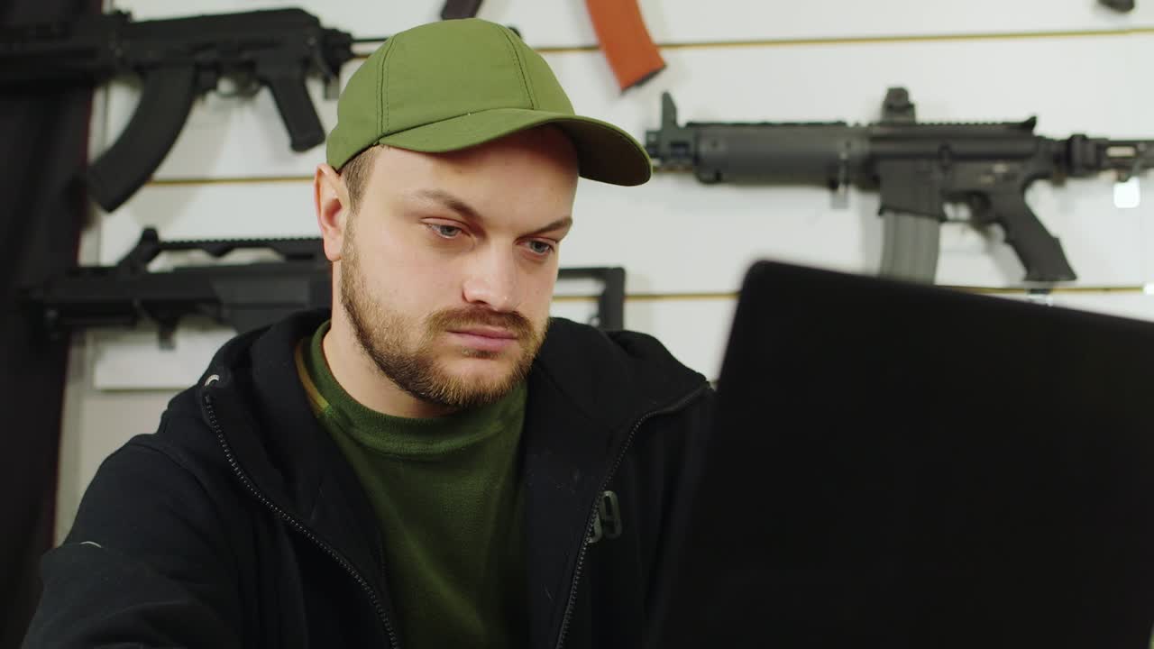 Premium stock video - Man behind a counter in an arms store 7