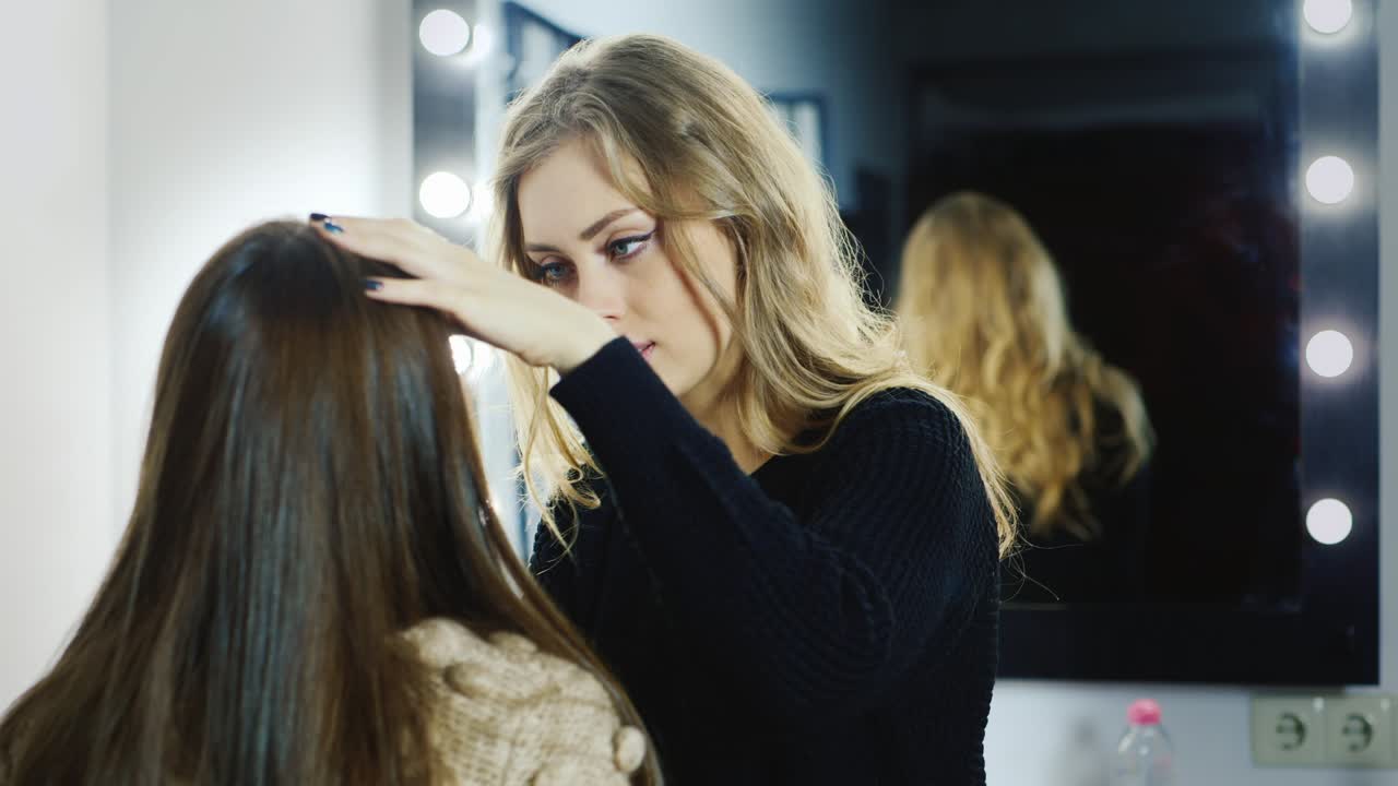 Premium stock video - Makeup artist does a young woman's make up in ...