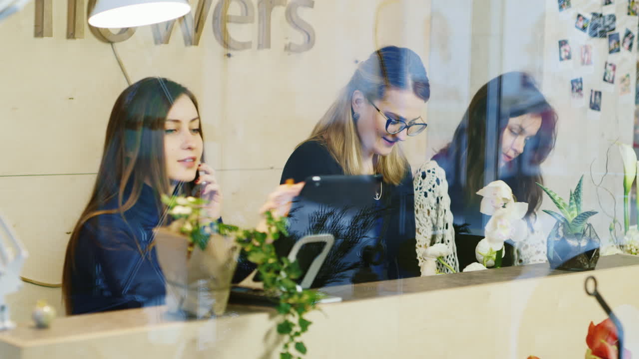 Premium stock video - The staff of the flower shop makes bouquets for ...