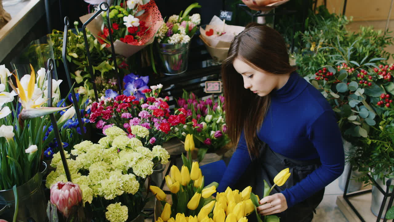 Vidéo de stock Premium - Un jeune fleuriste fait un bouquet dans un ...