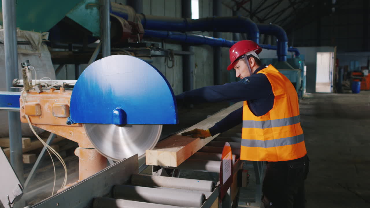 Premium stock video - A worker works in a sawmill