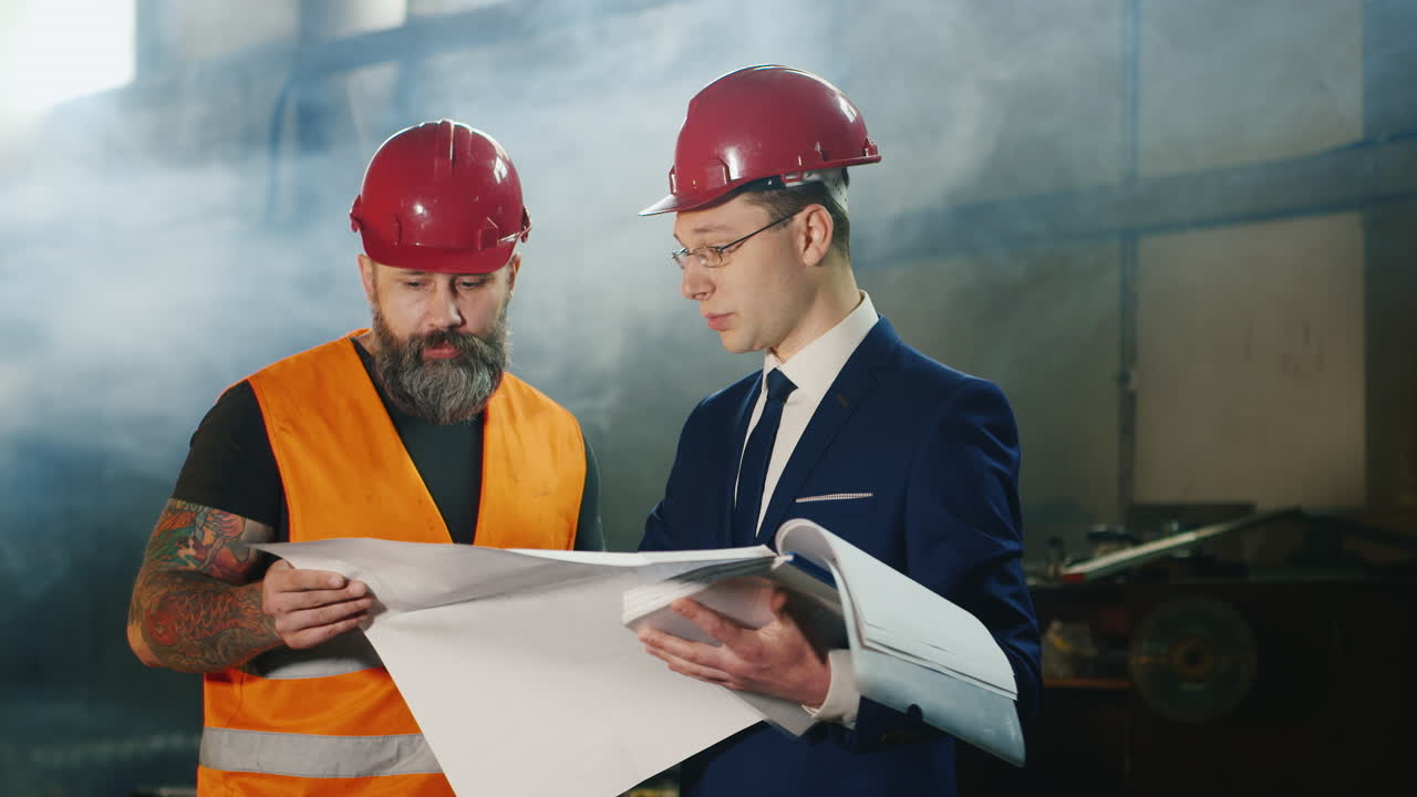 Premium stock video - Two engineers study drawings work in the warehouse