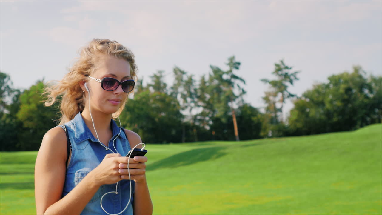 Premium stock video - A young attractive woman walks in a well-groomed ...