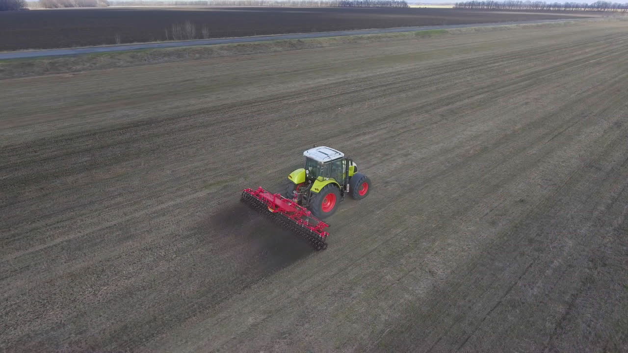 Premium stock video - The tractor draws an agricultural device for ...