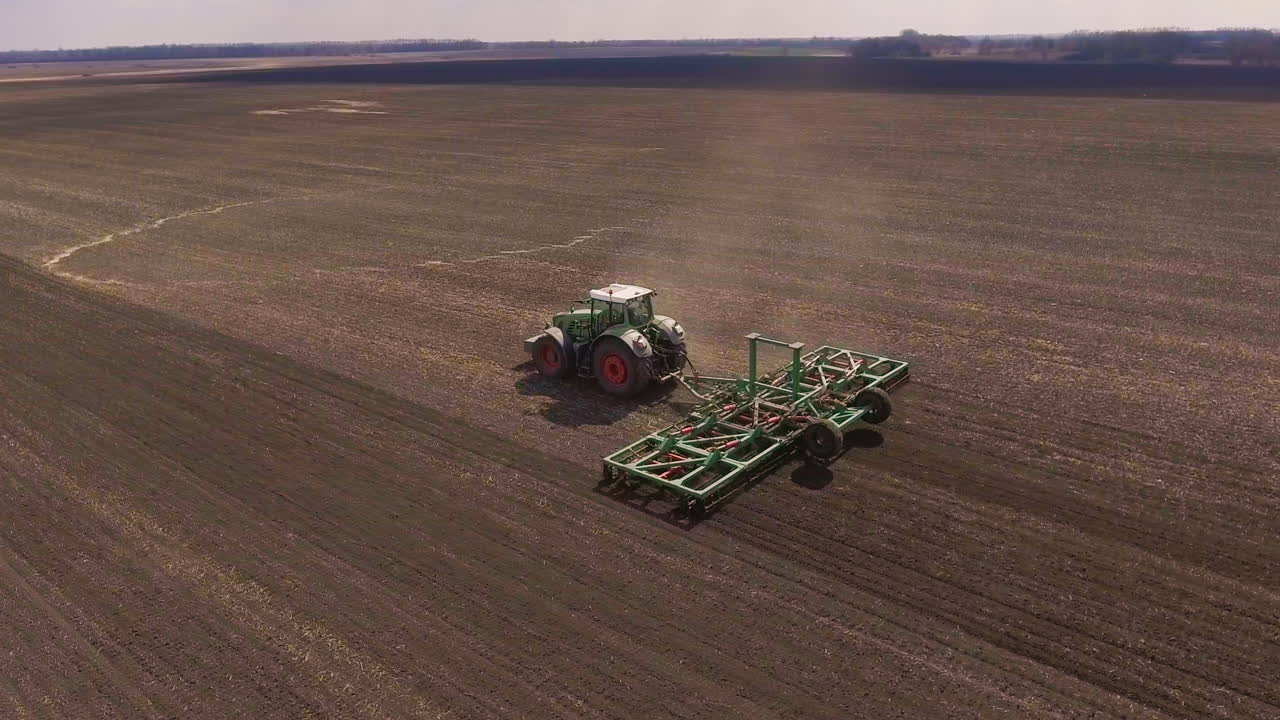 Premium stock video - The tractor draws an agricultural device for ...