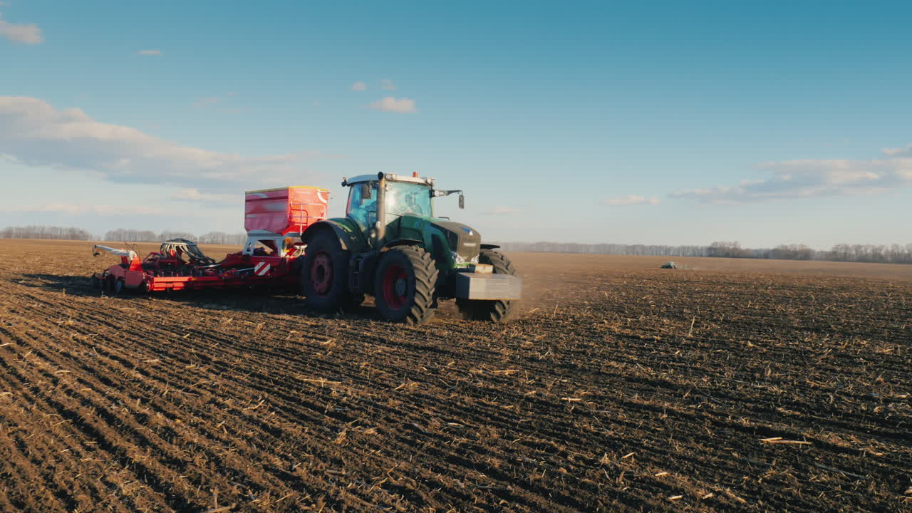 Premium stock video - Steadicam pan shot: tractors with seeders sow ...