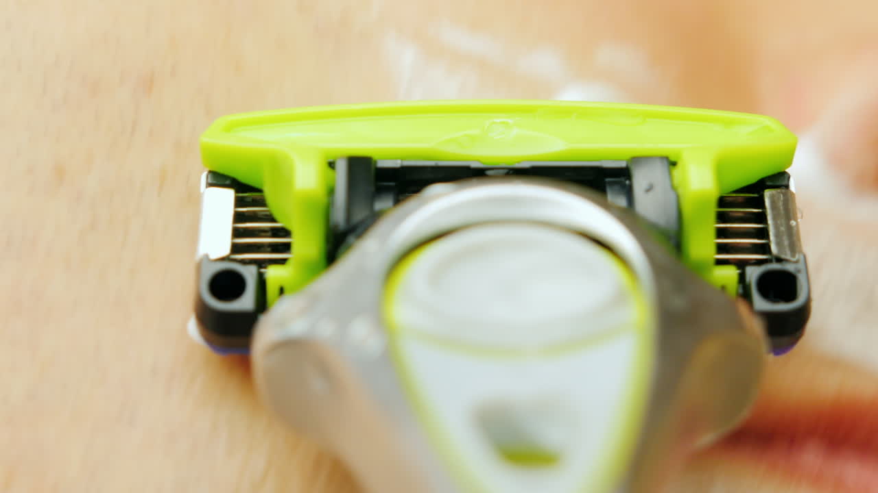 Premium stock video - Super close-up - a man shaving in the bathroom 2