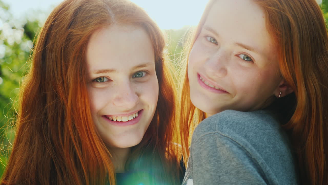 Premium stock video - Close-up portrait of two happy sisters twins