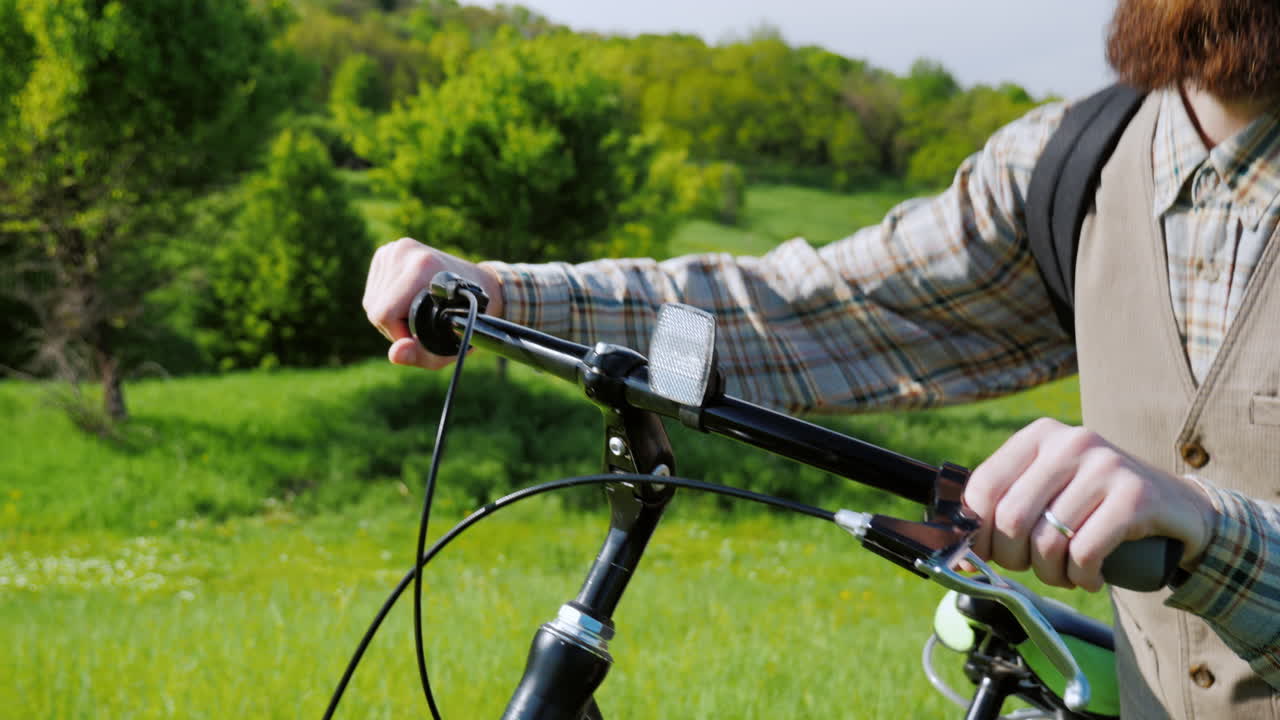 Premium stock video - A man drives a bicycle through a green meadow 1