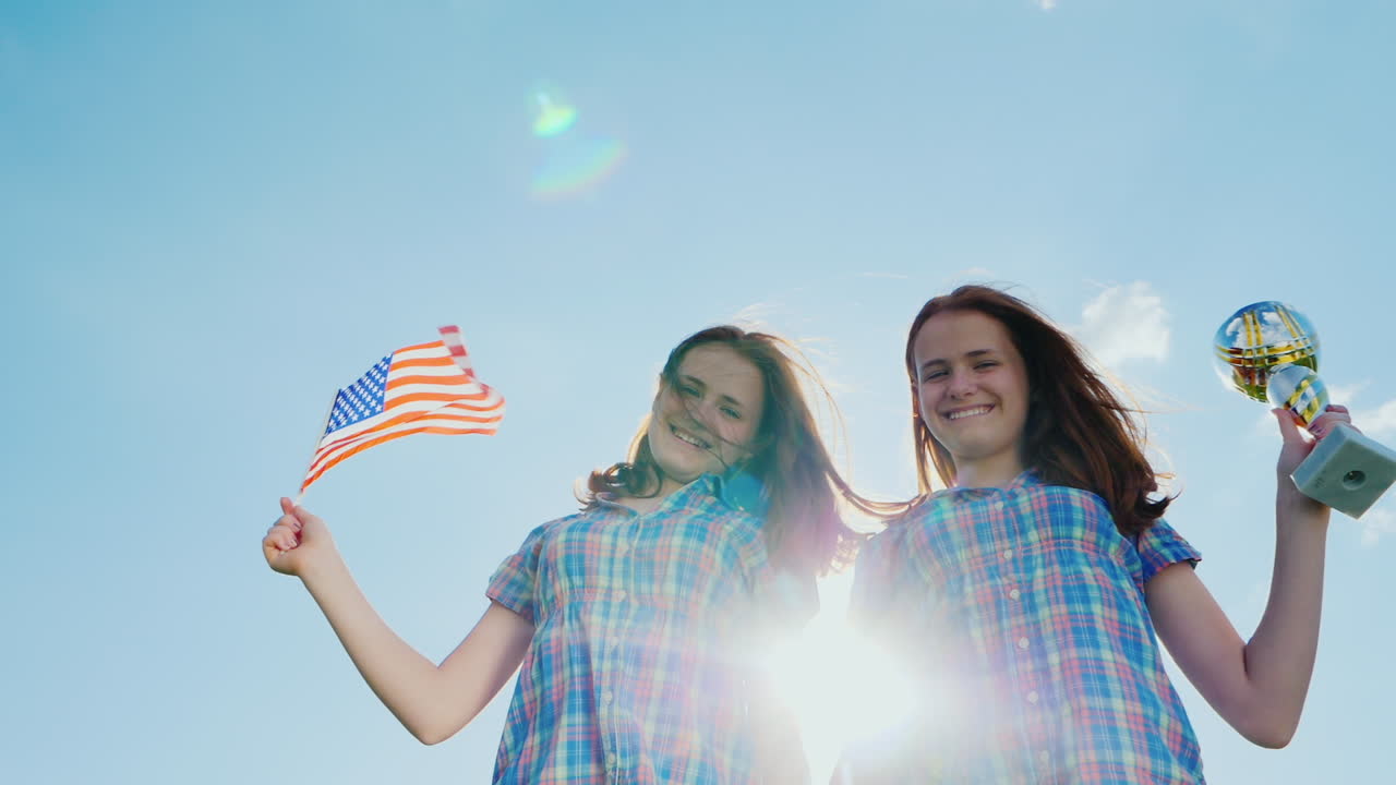 Premium stock video - Two teenage twins girls with a winner's cup and ...