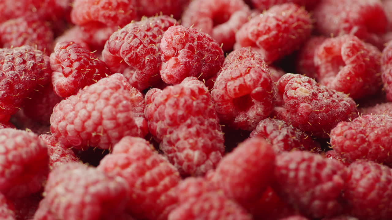 Premium stock video - Juicy red raspberries spin 1