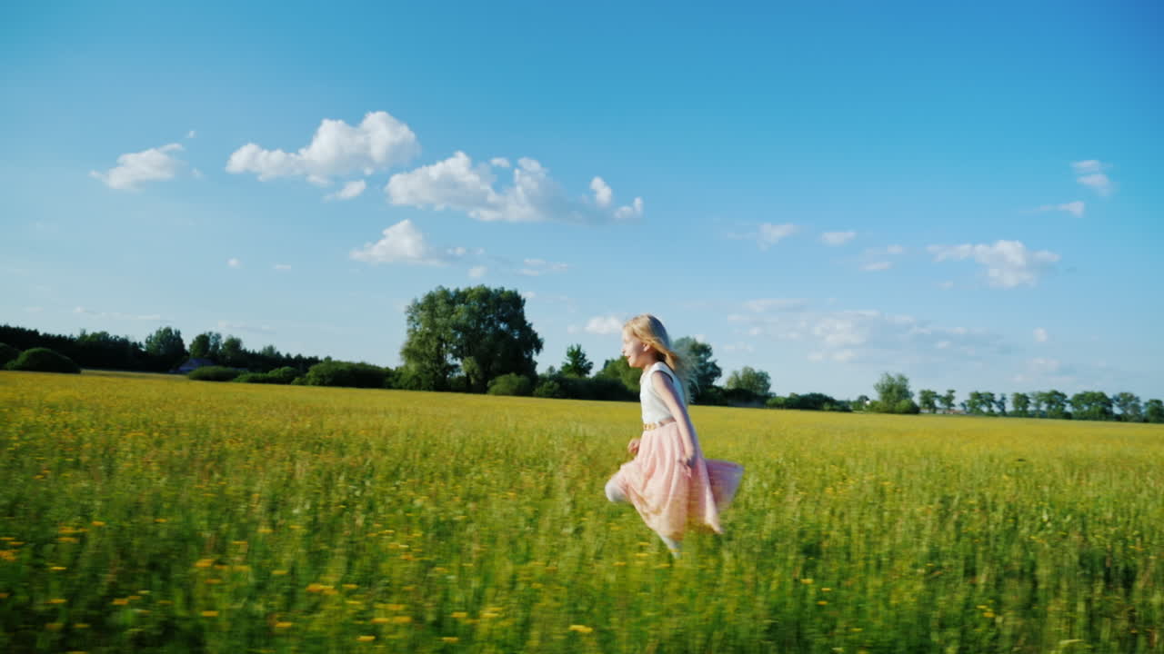 Premium stock video - A 6 year old girl in a pink dress runs across the ...