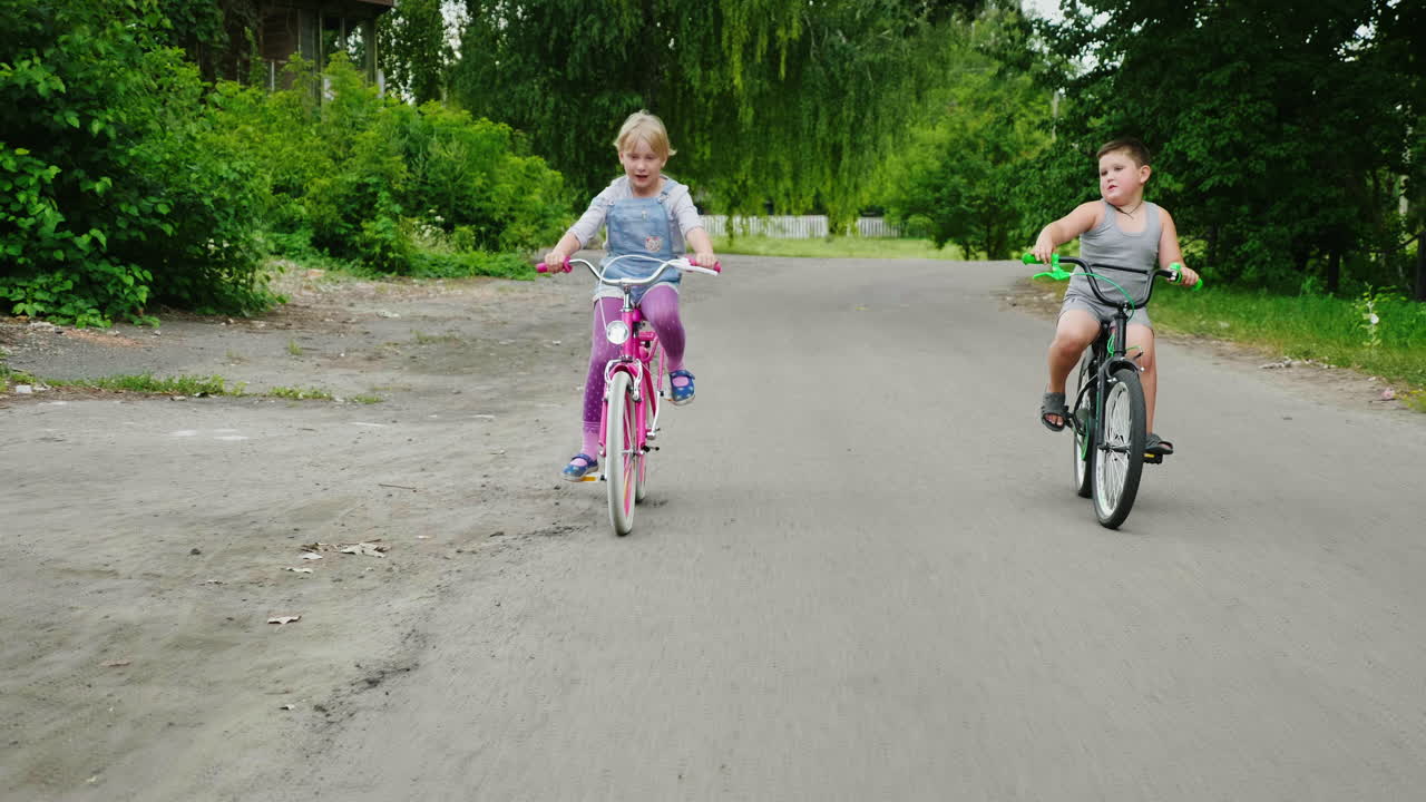 Premium stock video - Two farm children are riding bicycles in the ...