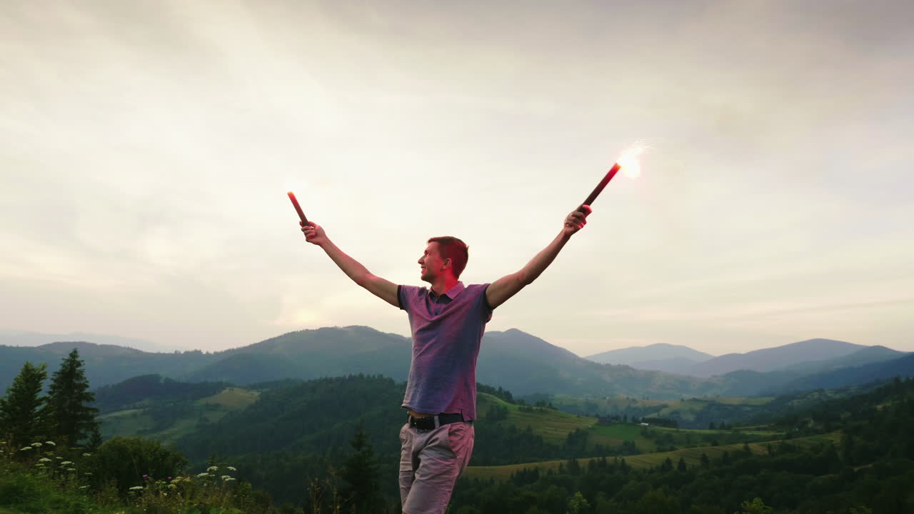 Premium stock video - A man in the mountains signals with hand ...