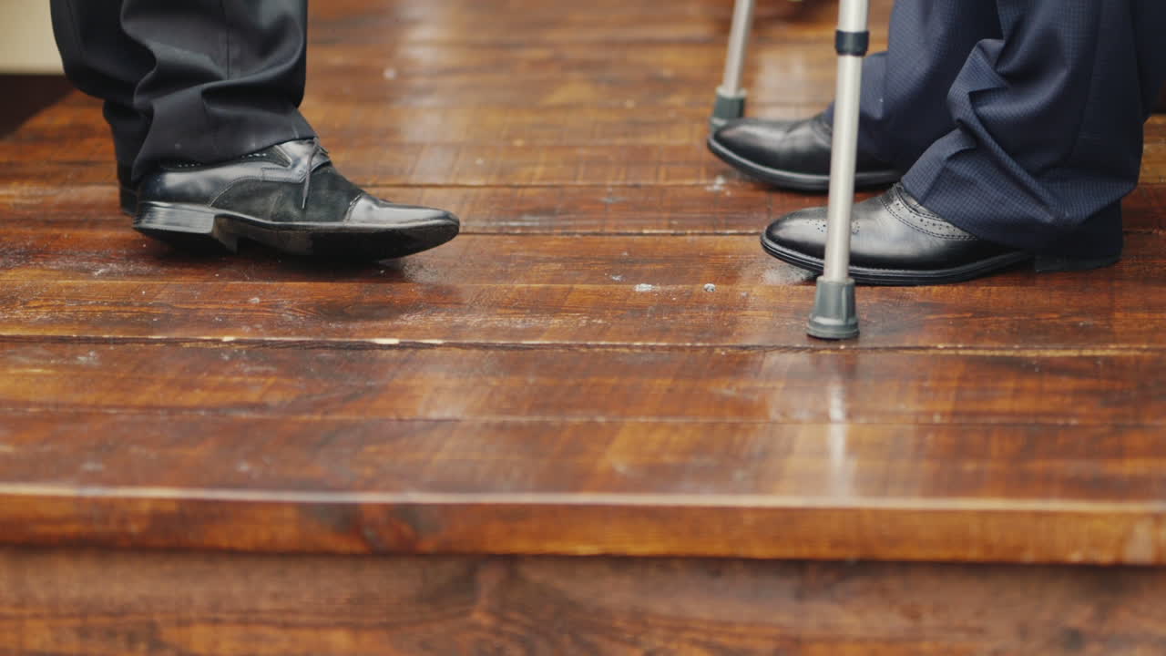 Premium stock video - A man on crutches communicates with another man Premium stock video - A man on crutches communicates with another man